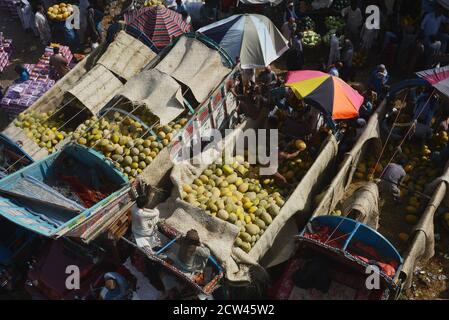 Pakistani farmers busy in their trucks loaded with watermelon at a ...