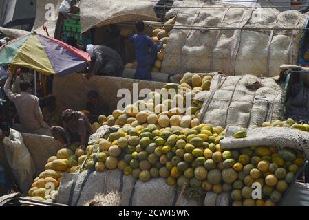 Pakistani farmers busy in their trucks loaded with watermelon at a ...