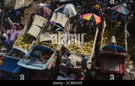 Pakistani farmers busy in their trucks loaded with watermelon at a ...