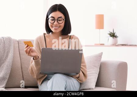 Young woman making purchases sitting on the floor Stock Photo - Alamy