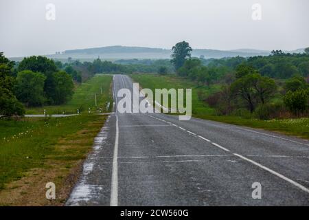 Asphalt road receding into the distance among green fields Stock Photo ...