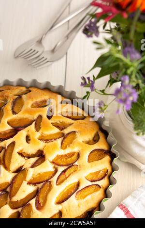 Plum pie at white table Stock Photo - Alamy