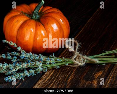 creepy and carved pumpkins on wooden stump near burning candle on black ...