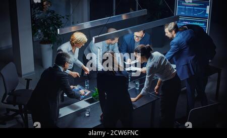 Colleagues lean on the conference table and discuss business, app UI ...