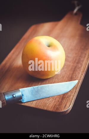 Organic fresh apple and pocket knife on a wooden cutting board. Apple ...