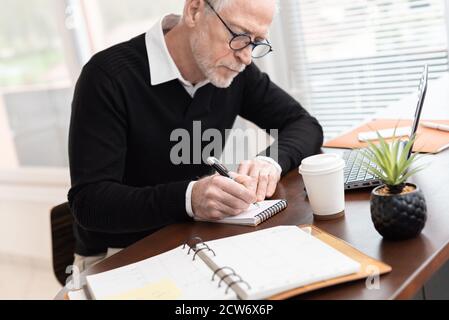 Senior businessman taking notes on notebook, geometric pattern Stock ...