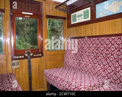 Historic railway carriage interior with polished wood paneling and drop ...