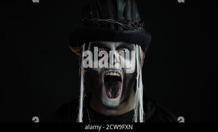 Man with skeleton creepy makeup trying to scare, opening his mouth and ...