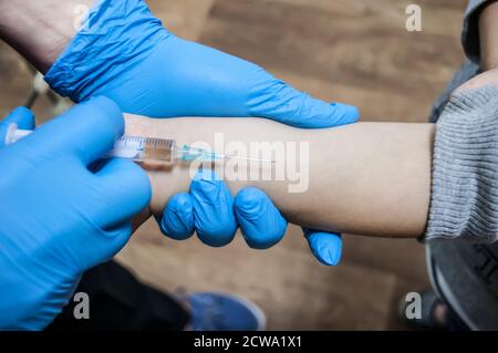 The doctor gives the child an injection in the buttock. Selective focus ...