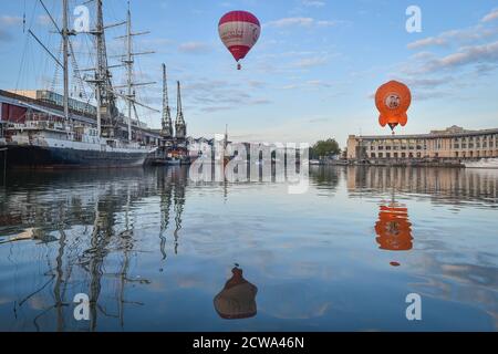 A reflection on the water during the maiden flight of a hot air balloon ...