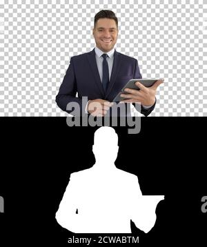 Handsome man swiping pages on tablet and smiling to camera on gradient ...