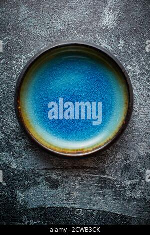 Top view of empty blue plate on cement background. Empty space for your ...