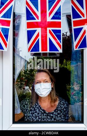 A woman looks out of her window during snowfall in Katoomba, NSW ...