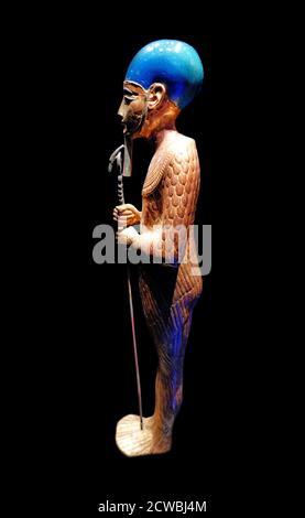 Gilded wooden statue of the God Ptah; wearing a cobalt blue glass cap ...