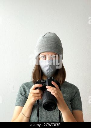 Young pretty woman in reusable virus protective pink mask on face ...