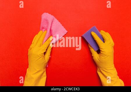 Hands in yellow gloves wipe surface of black induction stove close up ...