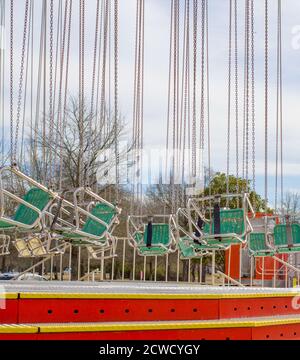A giant fun fair ride as thrill seekers spin around against a bright ...