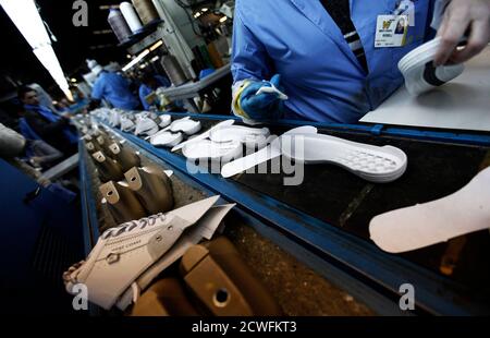 The conveyor on a shoes factory with shoe and sole. Mass production of ...