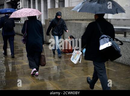 A homeless man sits in the rain with his dog in London Stock Photo - Alamy