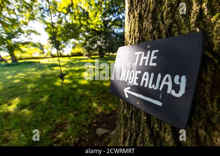 The Hideaway sign to glamping pod. Cool summer - shady Oak tree. Humble ...