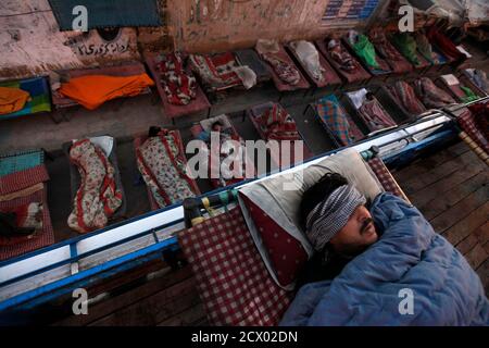 Homeless man beds down in his sleeping bag with his dog as companion on ...