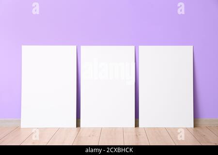 Blank posters near color wall Stock Photo - Alamy