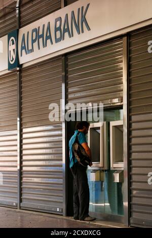 Man at an Alpha Bank ATM in Athens Greece Stock Photo - Alamy