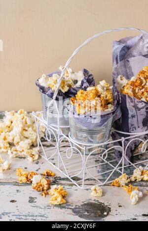 Caramelized popcorn in paper bucket on wooden kitchen table Stock Photo ...