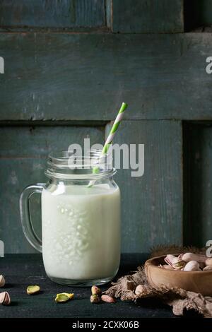 Some pistachios in a glass bowl on a black wooden table Stock Photo - Alamy