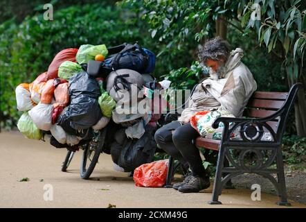 A homeless man on a bicycle with bags and box Stock Photo - Alamy