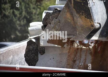 A bucket emptying its load into a dump truck Stock Photo - Alamy