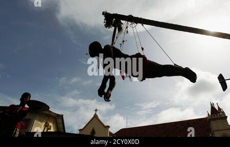 Man hanging on hooks pierced into his body (Tamil religion ritual ...