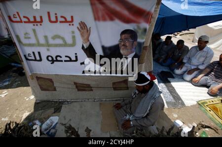 Egyptian soldiers perform afternoon prayers along the sand berm border ...