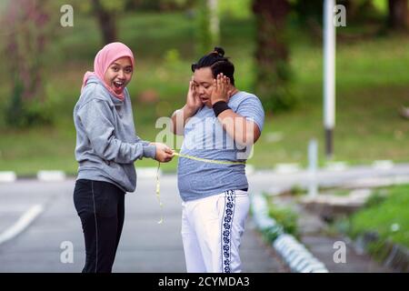 Two people, muslim woman and fat man, proportional and over weight ...