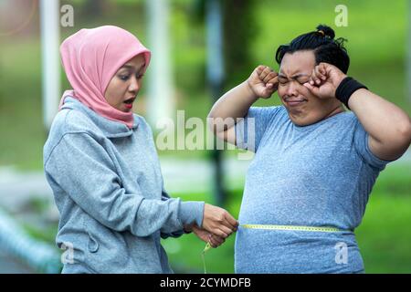 Two people, muslim woman and fat man, proportional and over weight ...