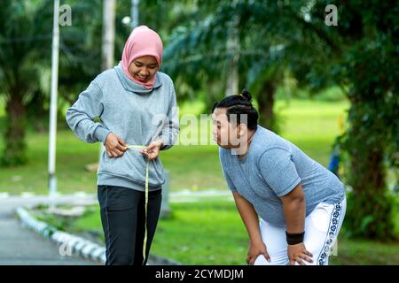 Two people, muslim woman and fat man, proportional and over weight ...