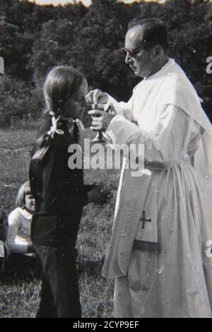 Nun receiving holy communion from the hands of a priest Stock Photo - Alamy