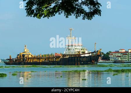 Dredger ship on Lake Vembanad passes Fort Cochin waterfront. Kochi is a ...