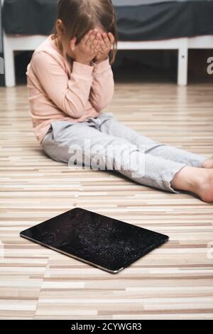 Little gird accidentally broke a tablet computer. Focus on cracked ...