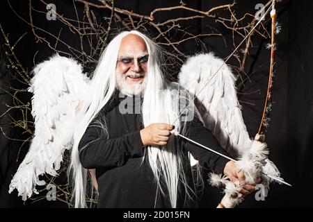 Bearded Man with angel wings. Senior man posing with angel wings. Tree ...