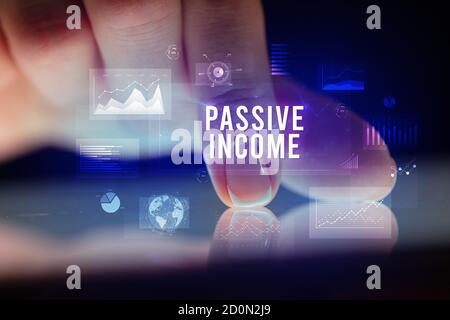 Finger touching tablet with charts and PASSIVE INCOME inscription ...