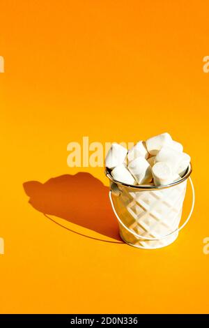 Marshmallow in bucket on pastel pink background Stock Photo - Alamy