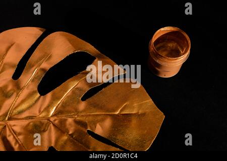 Gold tropical palm leaves Monstera on green background. Flat lay, top ...