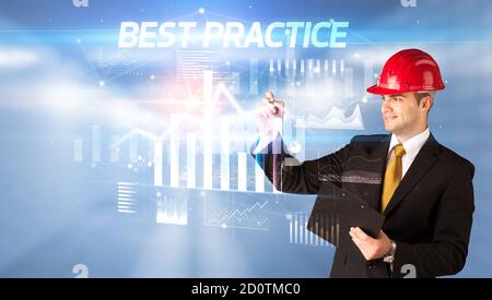 Handsome businessman with helmet drawing BEST PRACTICE inscription ...