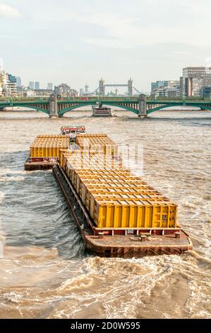 tug towing cory waste in sealed containers on barge in the river thames ...