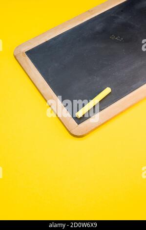 Vertical closeup of a blackboard with chalks on a yellow surface Stock ...