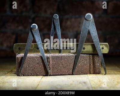Set of three engineers odd leg callipers on timber flooring resting ...