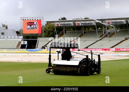 Ground staff operate the blotter machine as rain delays the start of ...