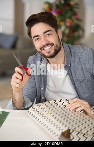 young man cutting wrapping paper Stock Photo - Alamy