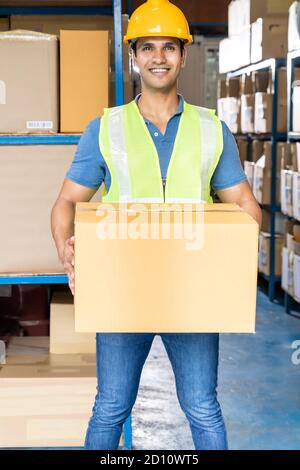Indian warehouse worker hold cardboard box Stock Photo - Alamy